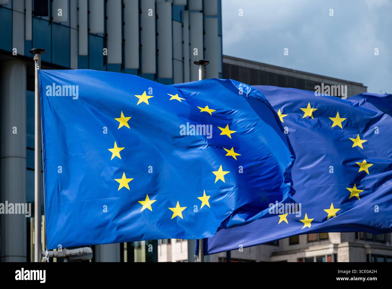 European Union flags waving in the wind against a modern buildings ...