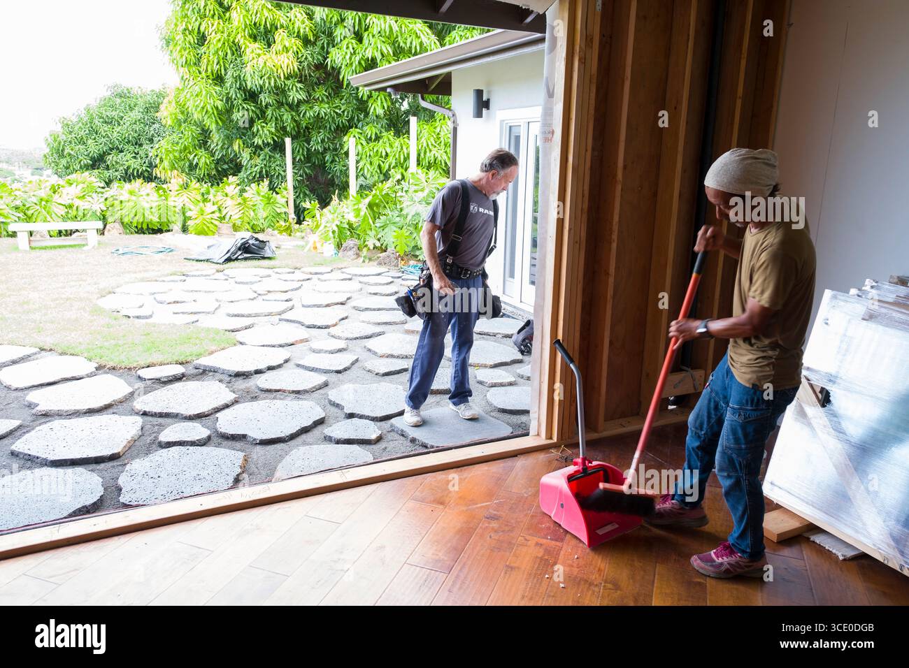 Construction worker sweeping floor during home remodel, Honolulu, Oahu ...