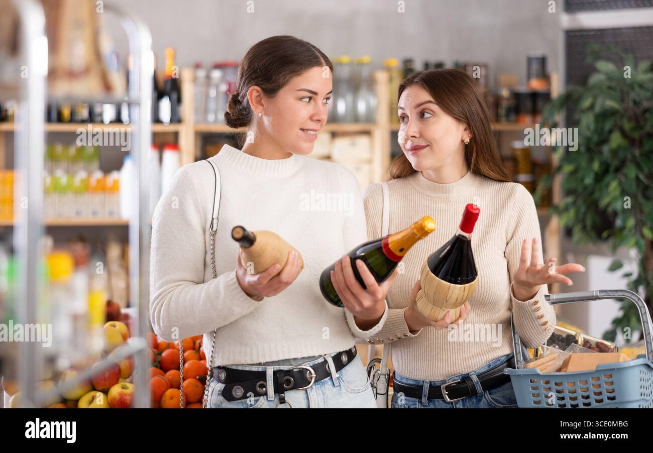 Two women choosing wine in a supermarket Stock Photo - Alamy