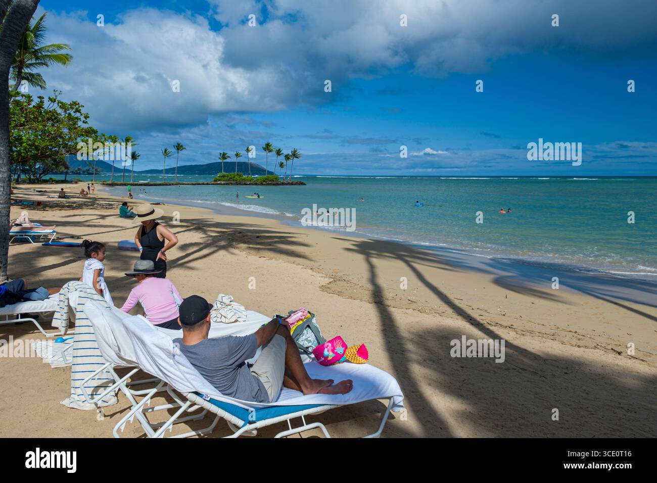 Guest relaxing on chase lounges on the beach at the Kahala Hotel & Resort, Kahala, Honolulu ...