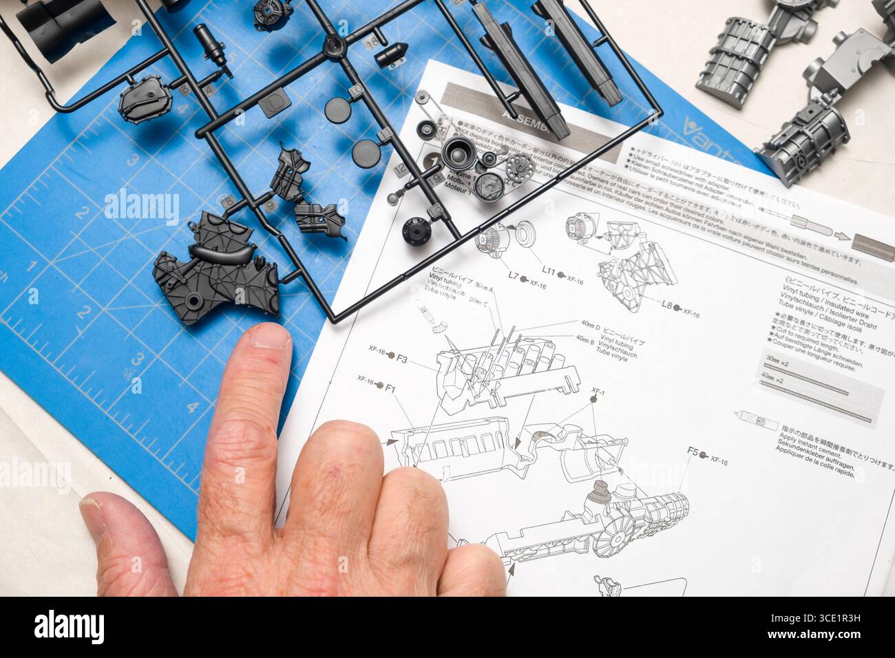 Man using instructions to find the proper polystyrene scale model part ...