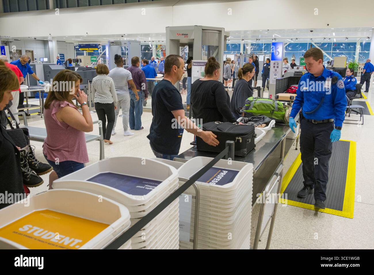 Passengers putting their baggage on counter for screening at the ...