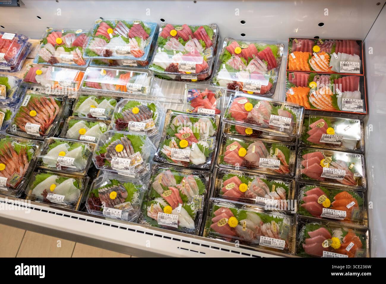 Selection of fresh sashimi packaged in clear plastic containers in ...