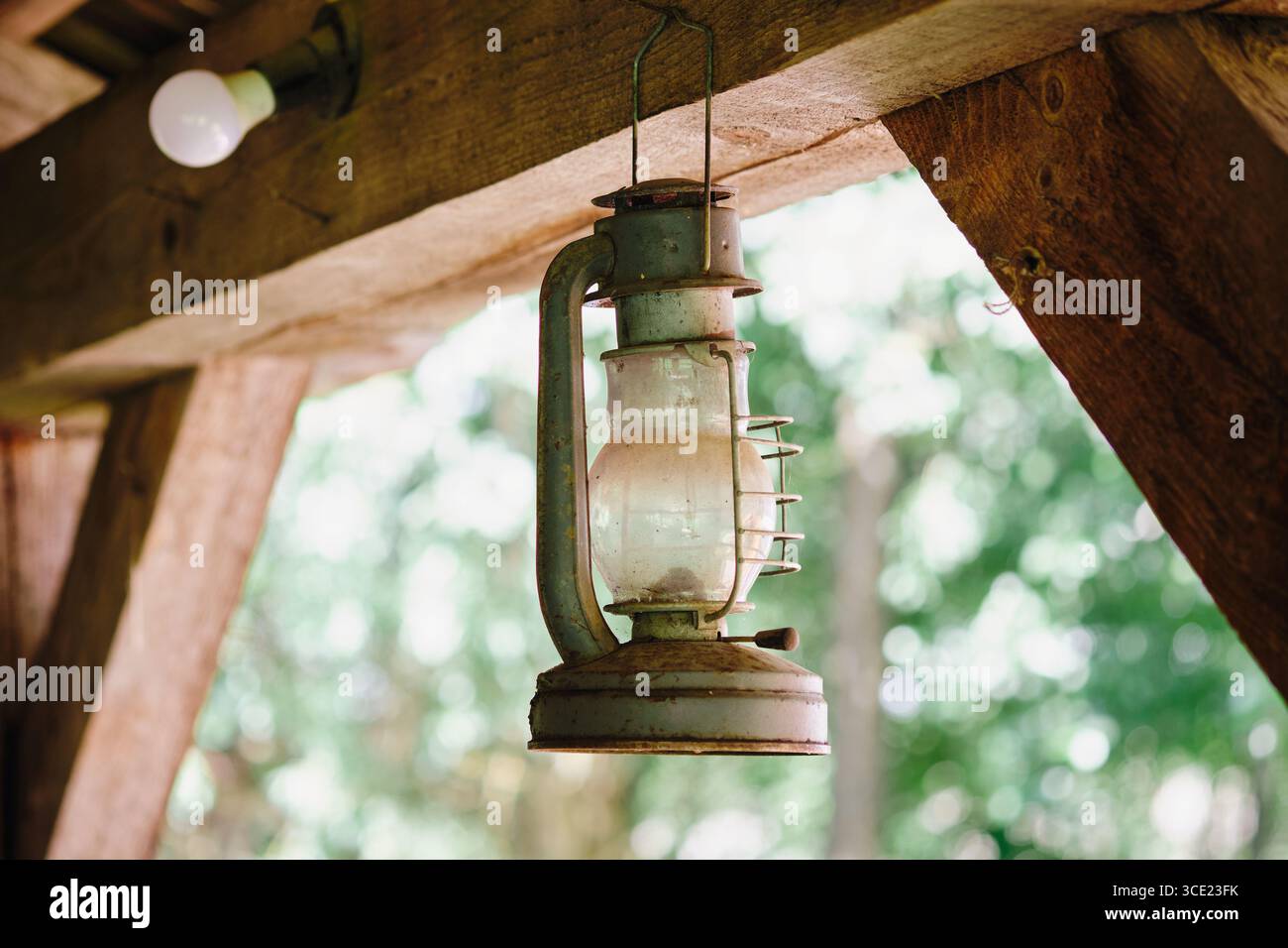 An antique grey lantern hangs from the wooden rafters. Natural light ...