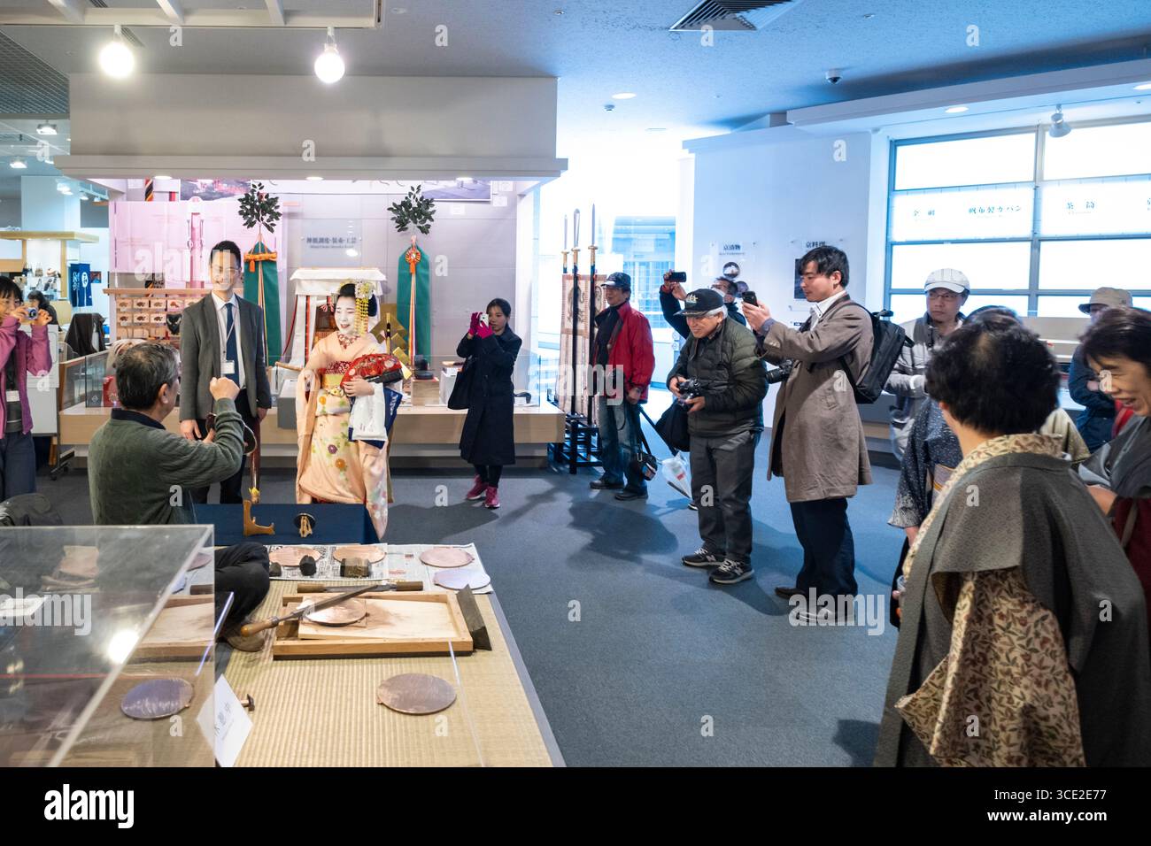 Male artisan who makes handcrafted mirrors speaking to a visiting Maiko ...
