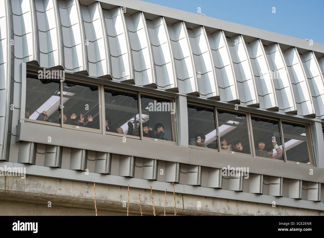 Children waving and looking out of windows at the Umekoji-Kyotonishi ...
