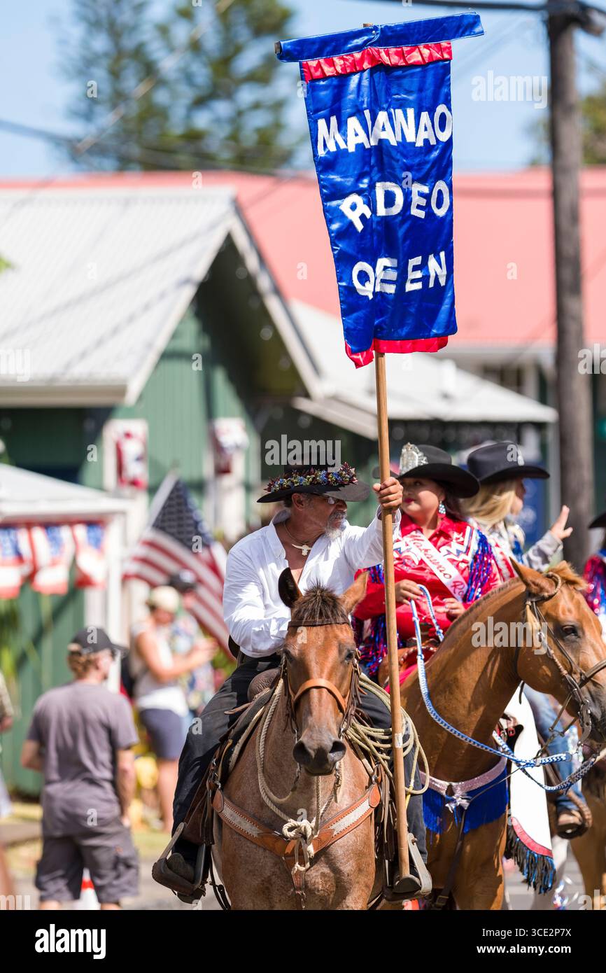 Man on horseback holding a vertical banner for the Makawao Rodeo Queen ...