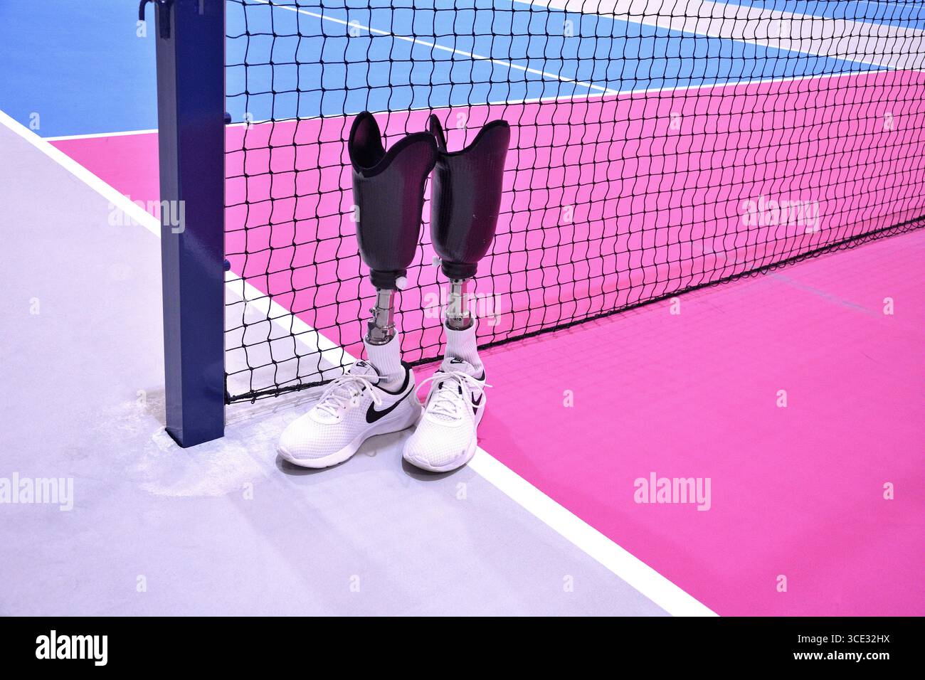 A pair of below-knee prosthetic legs, standing side-by-side on the edge ...