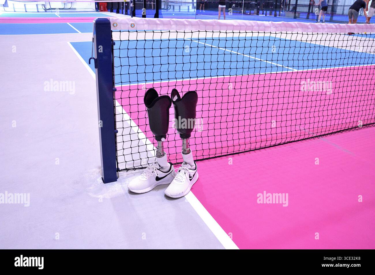 A pair of below-knee prosthetic legs, standing side-by-side on the edge ...