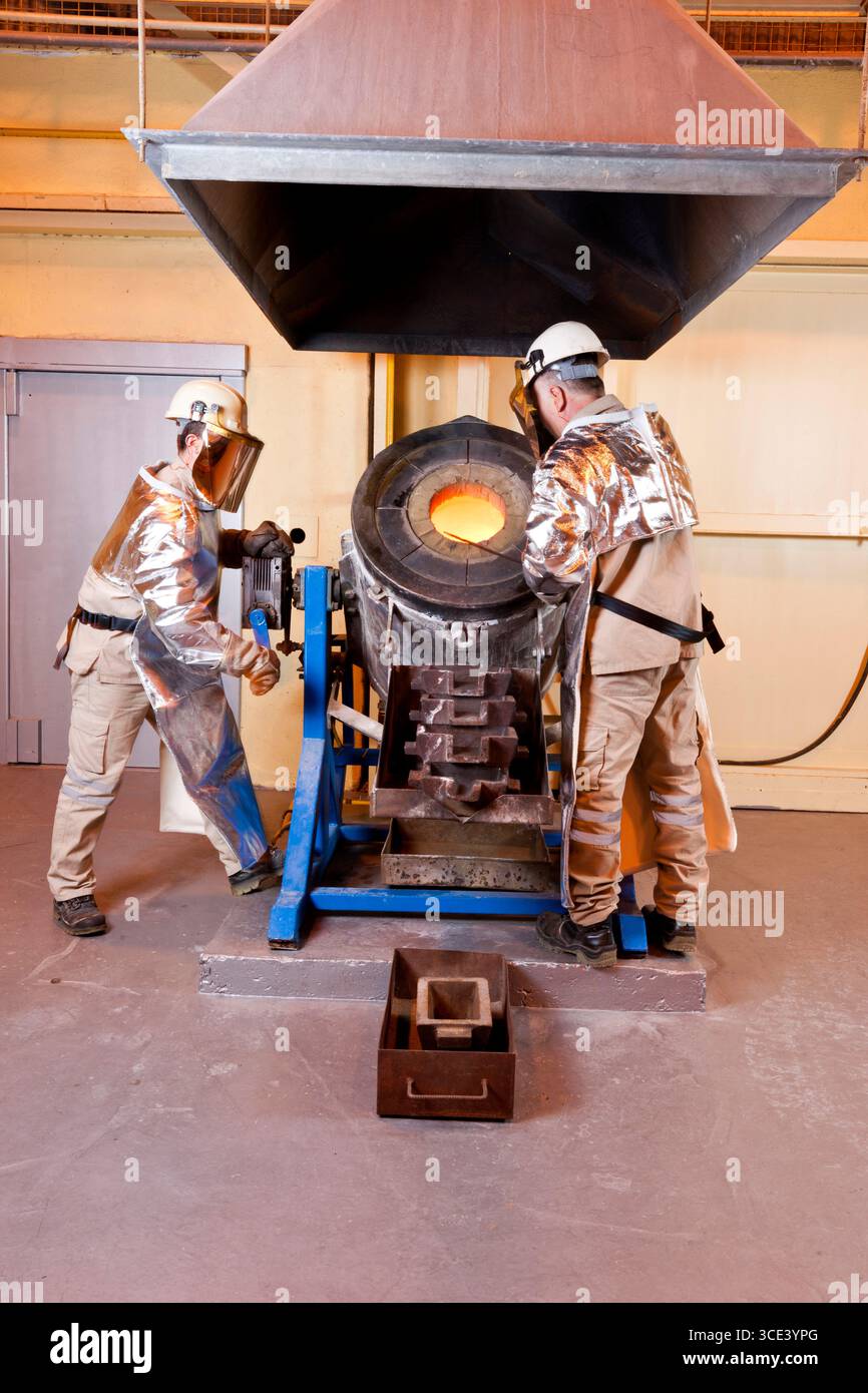 Filling casting form with melted gold in shielding gases Stock Photo ...