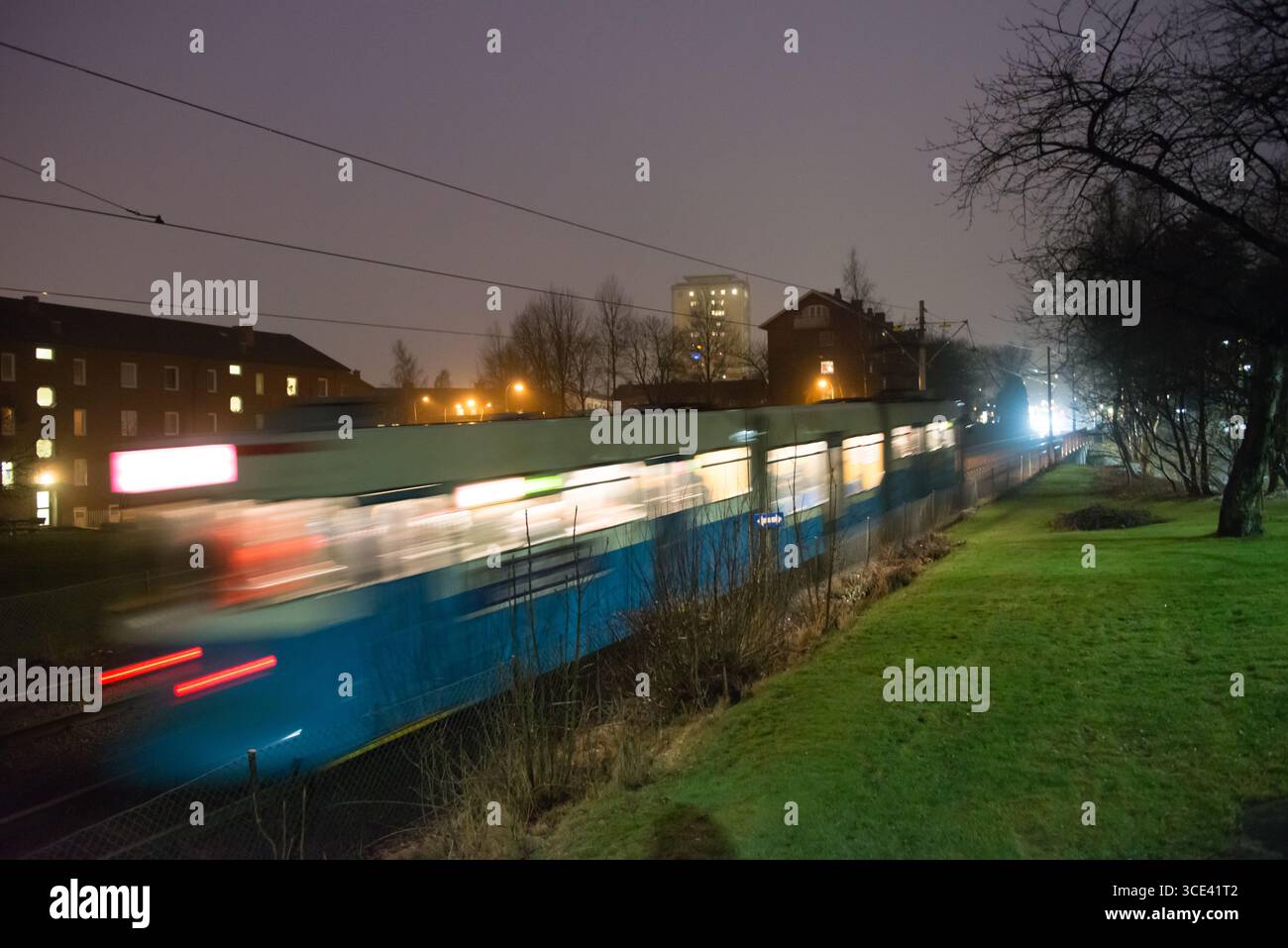 Tram passing a dark stretch of a tram line Stock Photo - Alamy