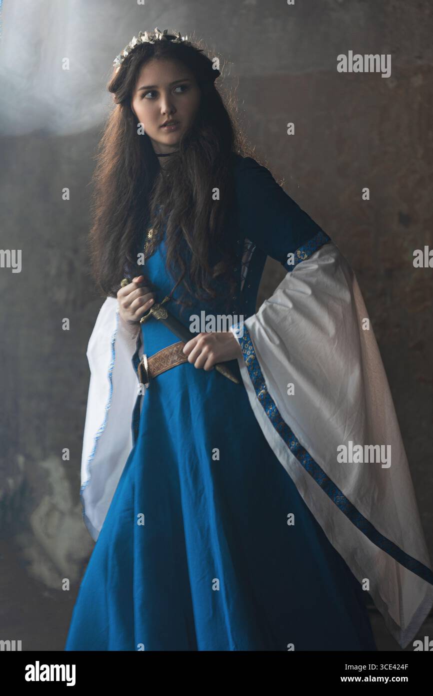 Fantasy heroine with dagger, brunette in ornate blue dress and silver ...