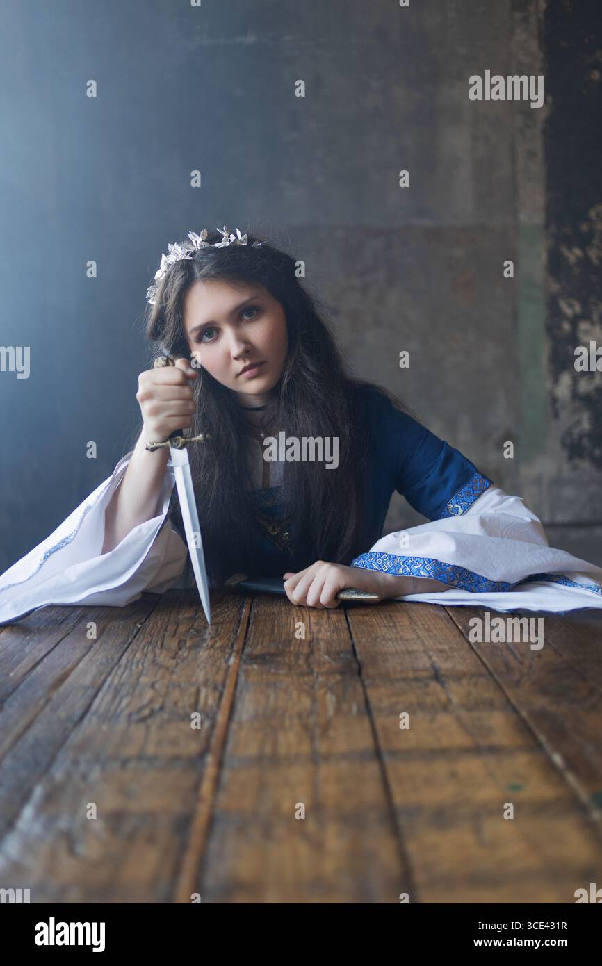 Noble warrior princess with dagger, long hair cascading over her blue ...