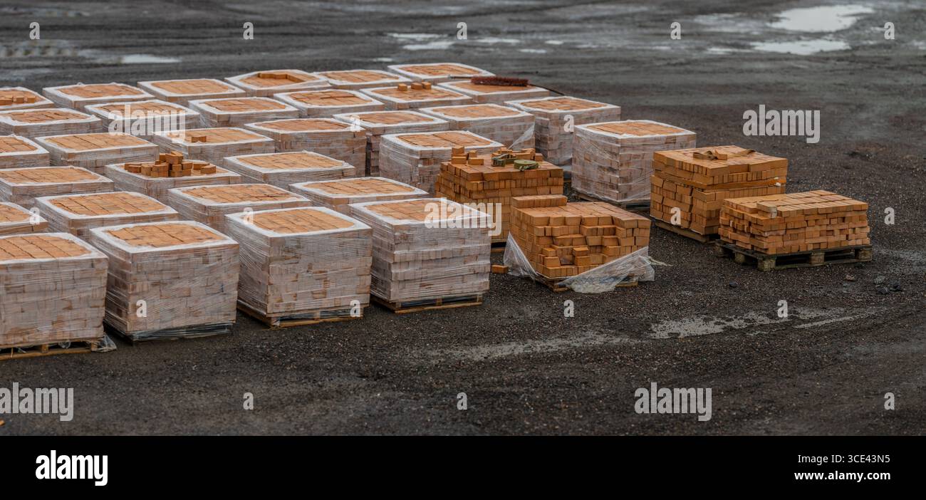 Multiple pallets of teal bricks at a building site Stock Photo - Alamy