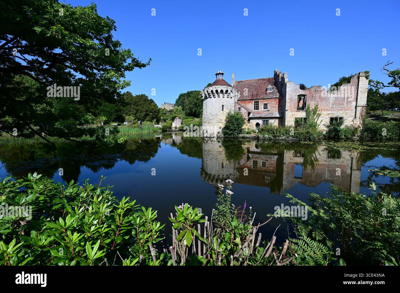 Ruins of a Medieval Moated Manor house by a lake in summertime Stock ...