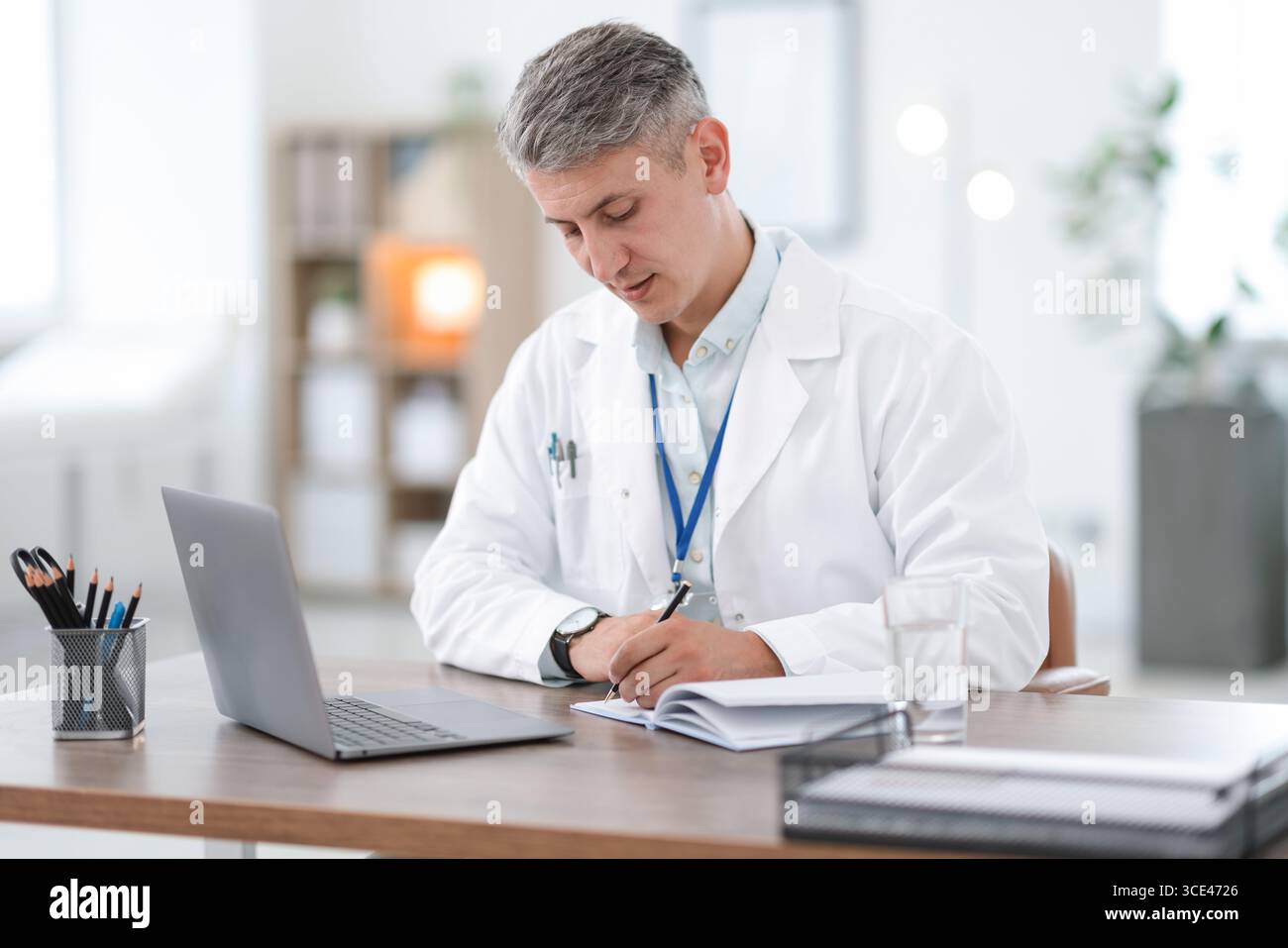 Telemedicine. Doctor making notes while having video call with patient ...