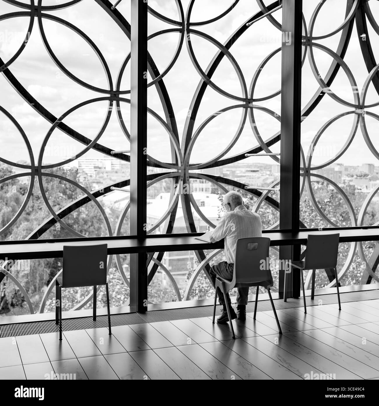 Expanding Horizons - Lone man elderly studying in a Library against a ...