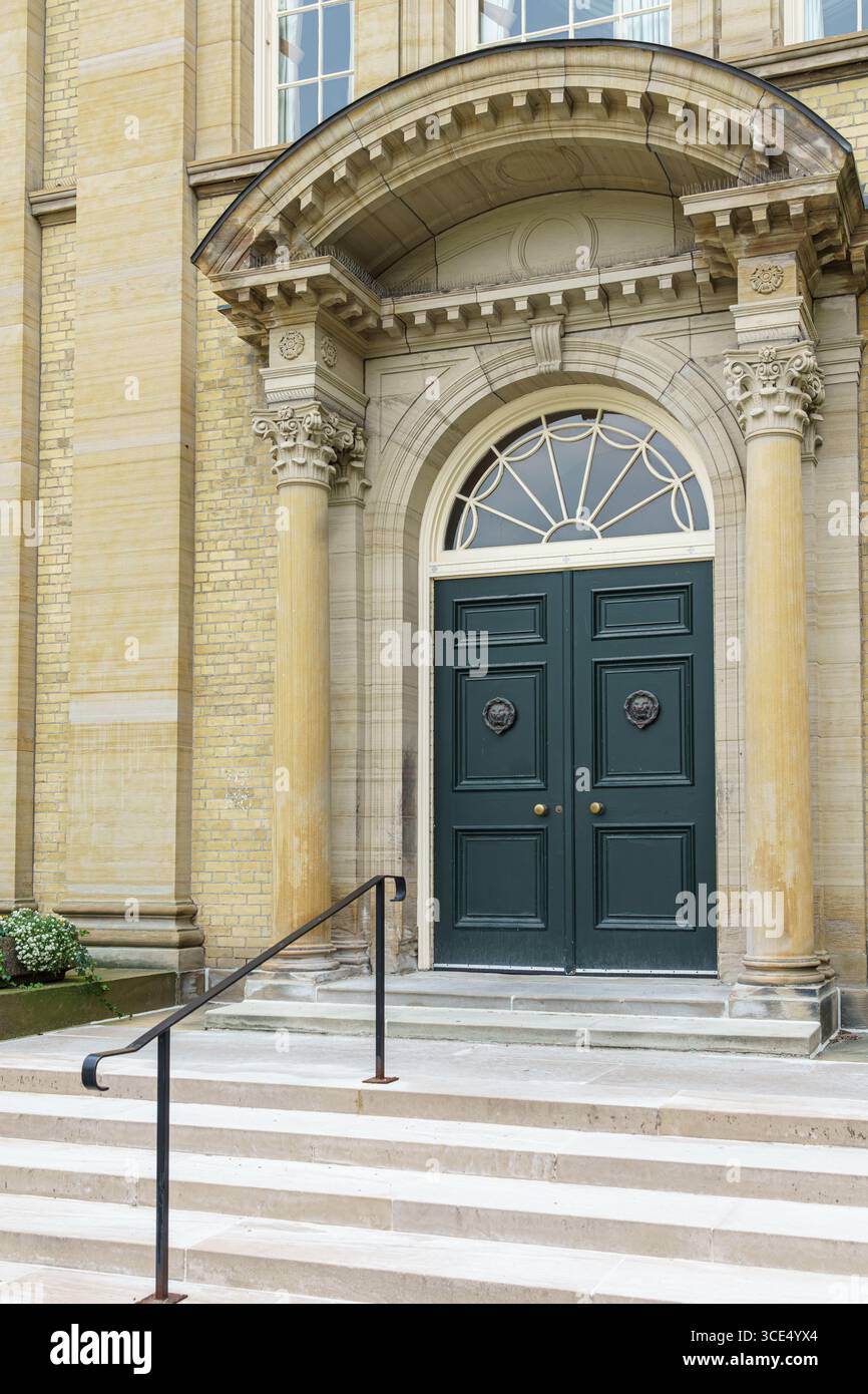 Arched doorway with dark double doors and columns at St. George Campus ...