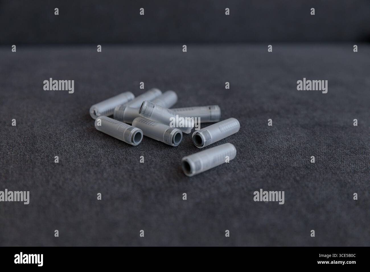 This image captures a cluster of gray plastic tubes neatly arranged on ...
