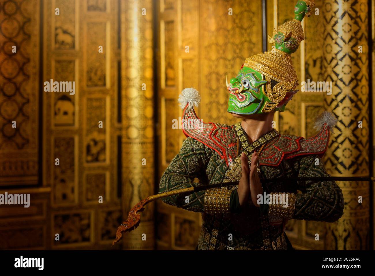 Traditional khon dancer in a mask and stage costume performing inside a ...