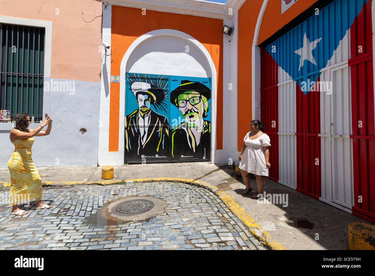 Tourists takes phots next to a mural featuring Bad Bunny and Elizam ...