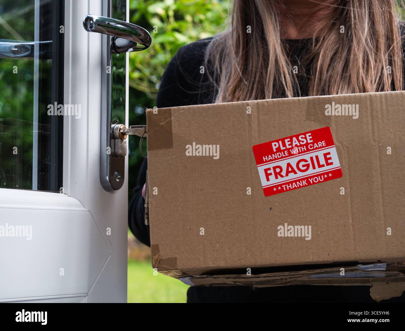 Woman delivering fragile box knocking hi-res stock photography and images - Alamy
