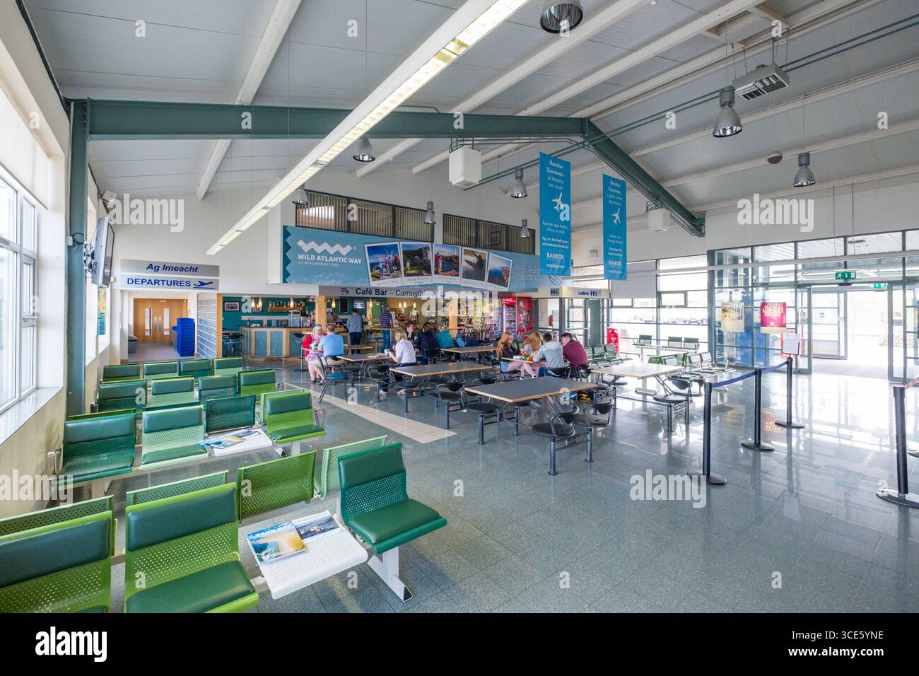 People sitting in small passenger lounge inside rural Donegal Airport ...