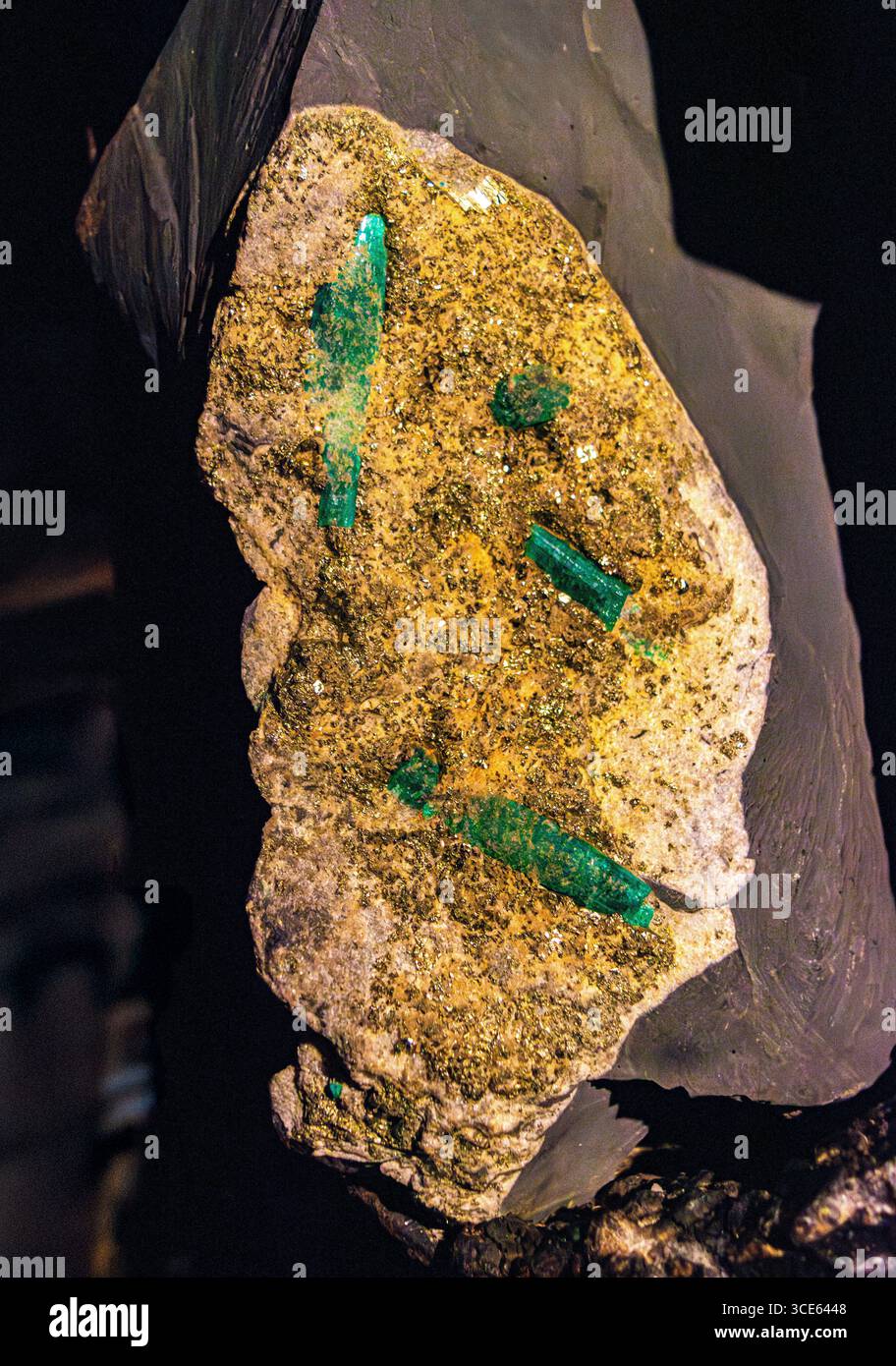 A stunning natural rock featuring vibrant Colombian emeralds showcased ...