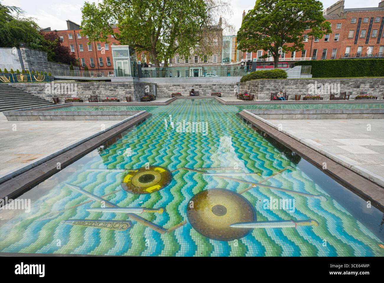 Sunken cruciform water-feature with mosaic of broken weapons cast in ...