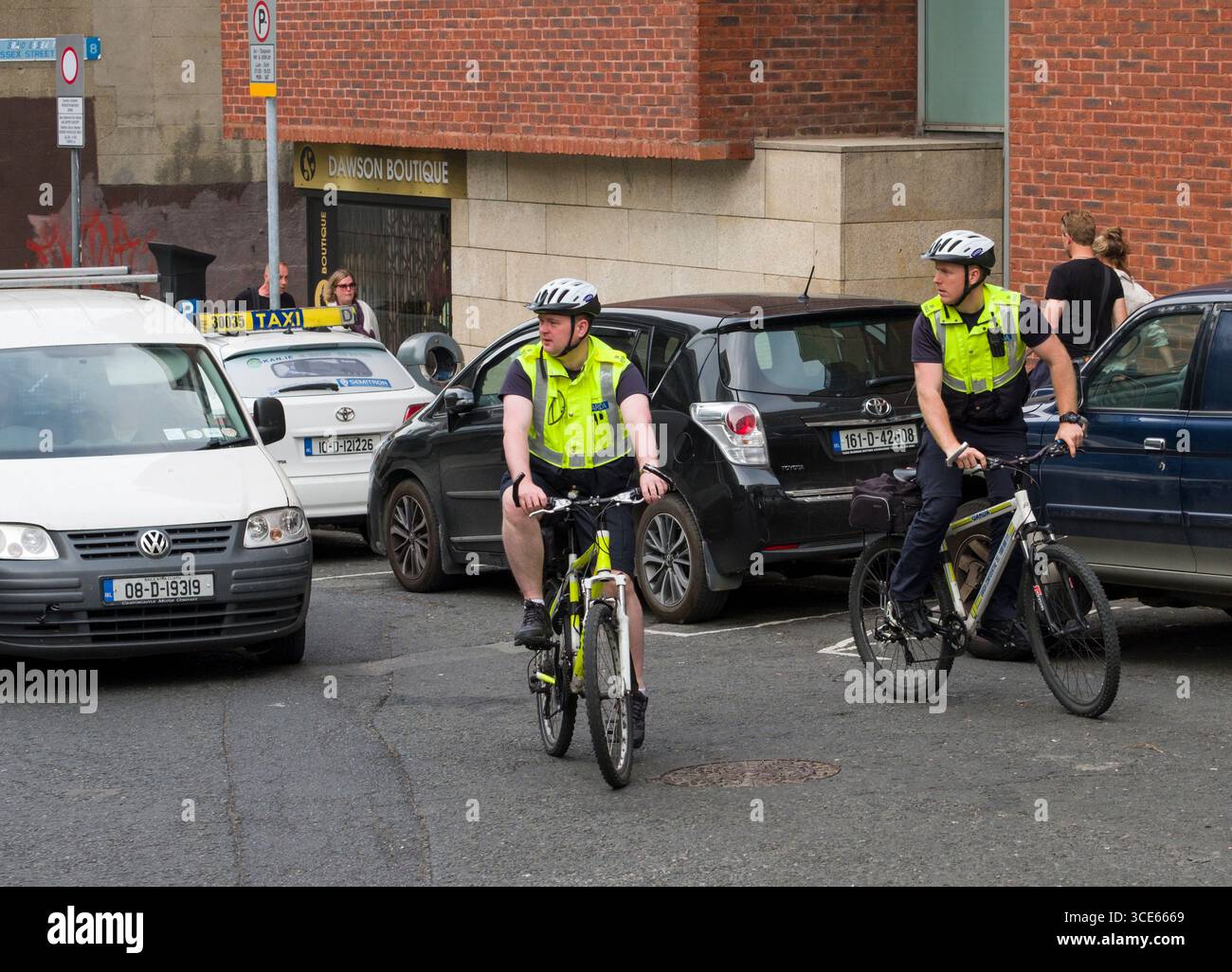 Gardaí officers on bicycle patrol wearing helmets and high visibility ...