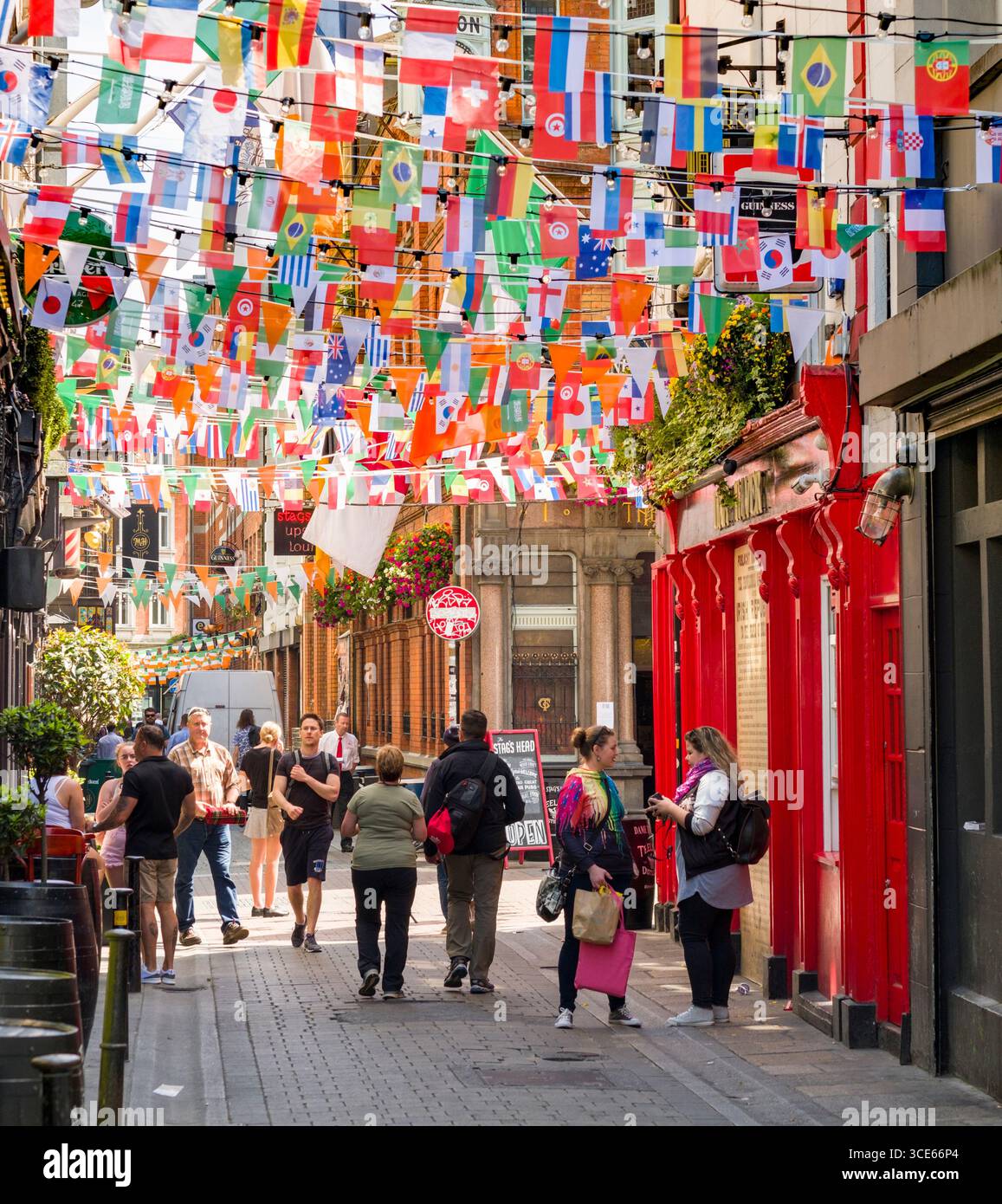 Small colorful national flags of many countries strung above Dame Lane ...