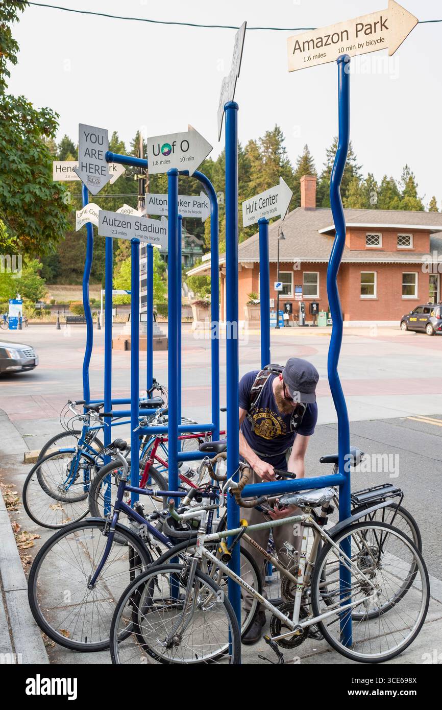 Man locking his bicycle to a bike rack, Eugene, Lane County, Oregon ...