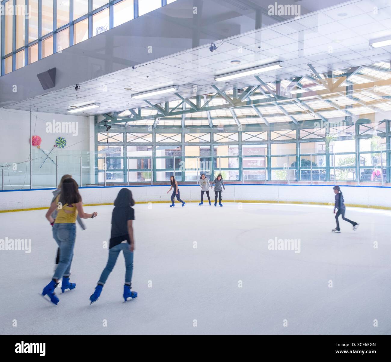 Adults and children ice skating inside the Promenade Ice Chalet indoor ...