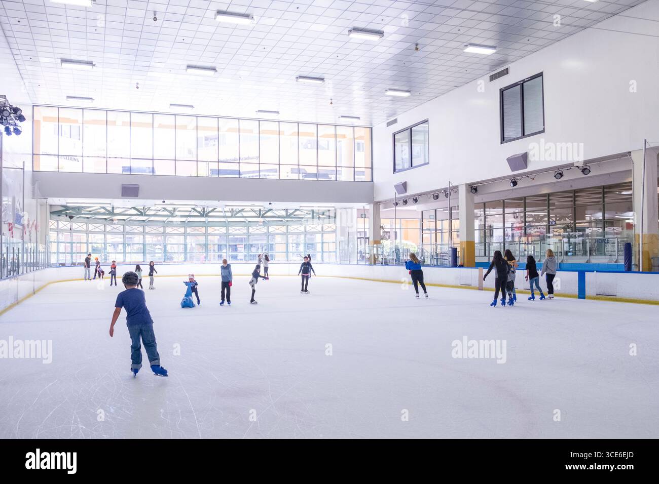 Adults and children ice skating inside the Promenade Ice Chalet indoor ...