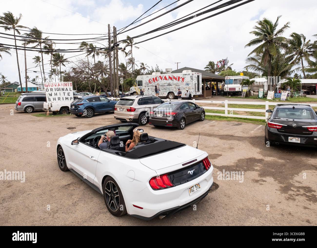 White Ford convertible Mustang sports car with top down in parking lot ...