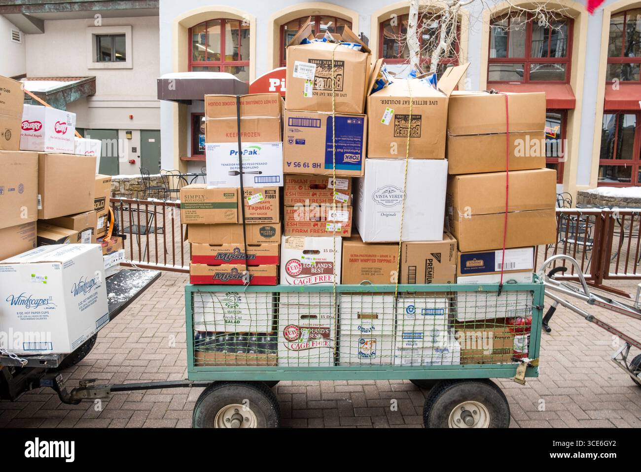 Trailer stacked high with various cardboard boxes behind a Cushman 4WD ...