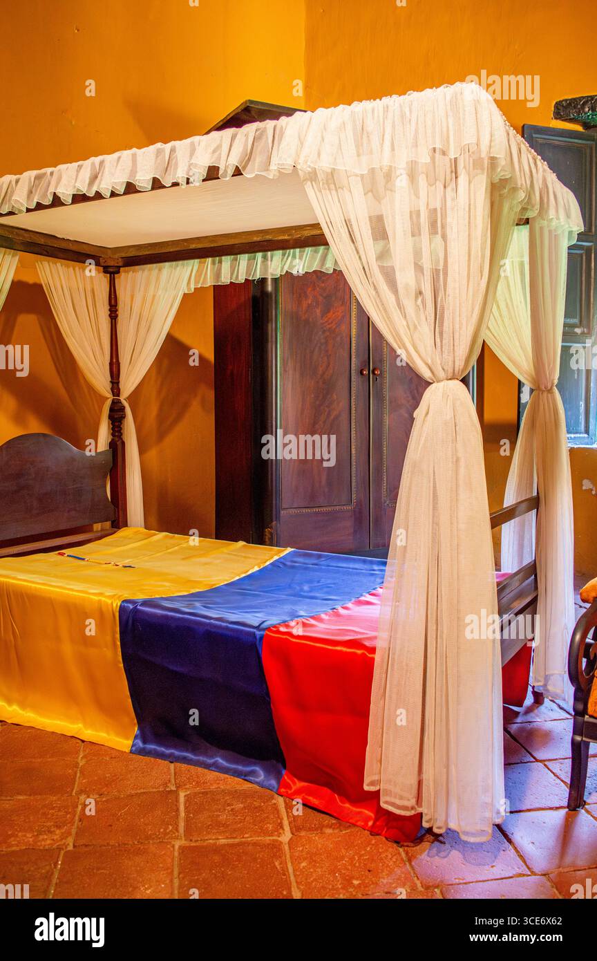 A beautifully draped bed featuring the colors of the Colombian flag in ...