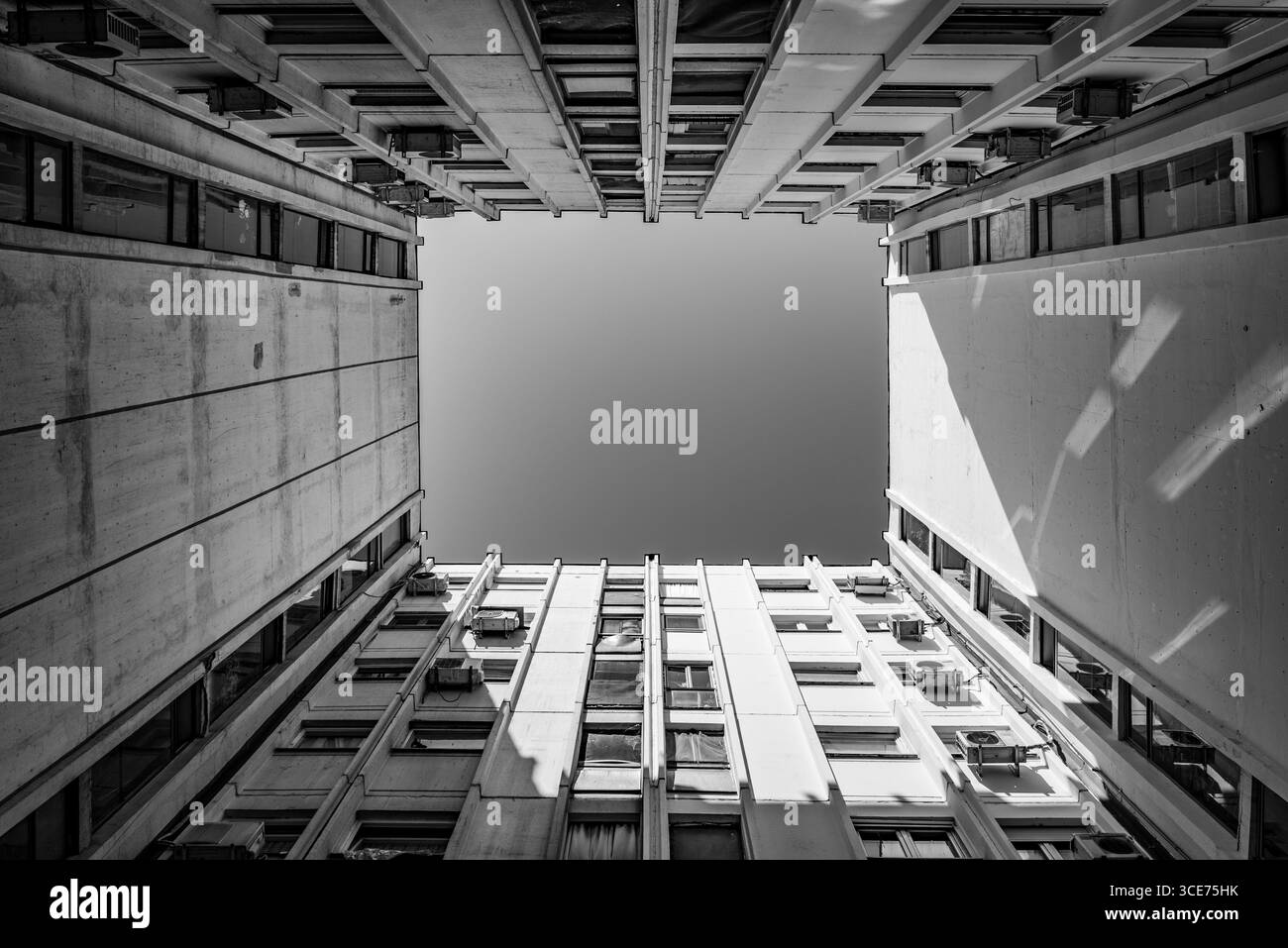 Black and white view of tall buildings forming a narrow tunnel, looking ...