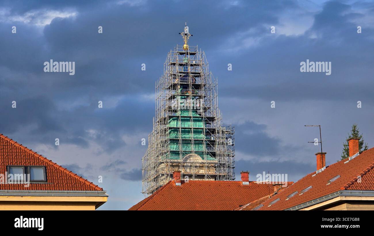 Church tower with green dome and intricate facade is covered by ...