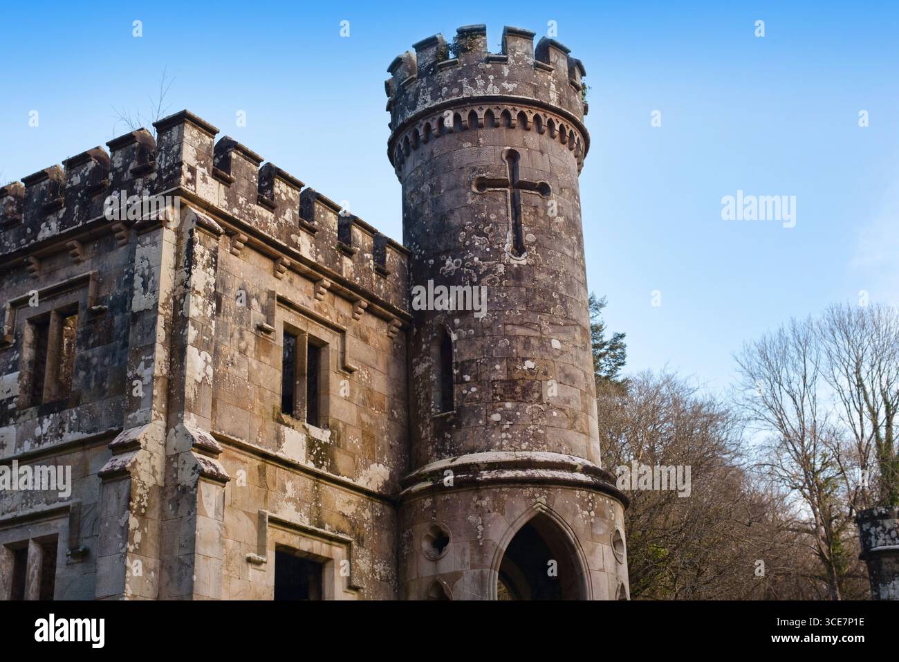 Historic stone castle tower with cross under clear blue sky. Old stone ...