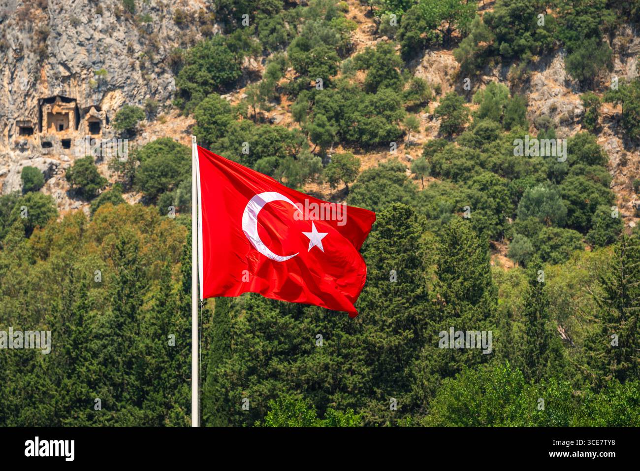 Turkish flag waving with Lycian rock tombs in background Stock Photo ...