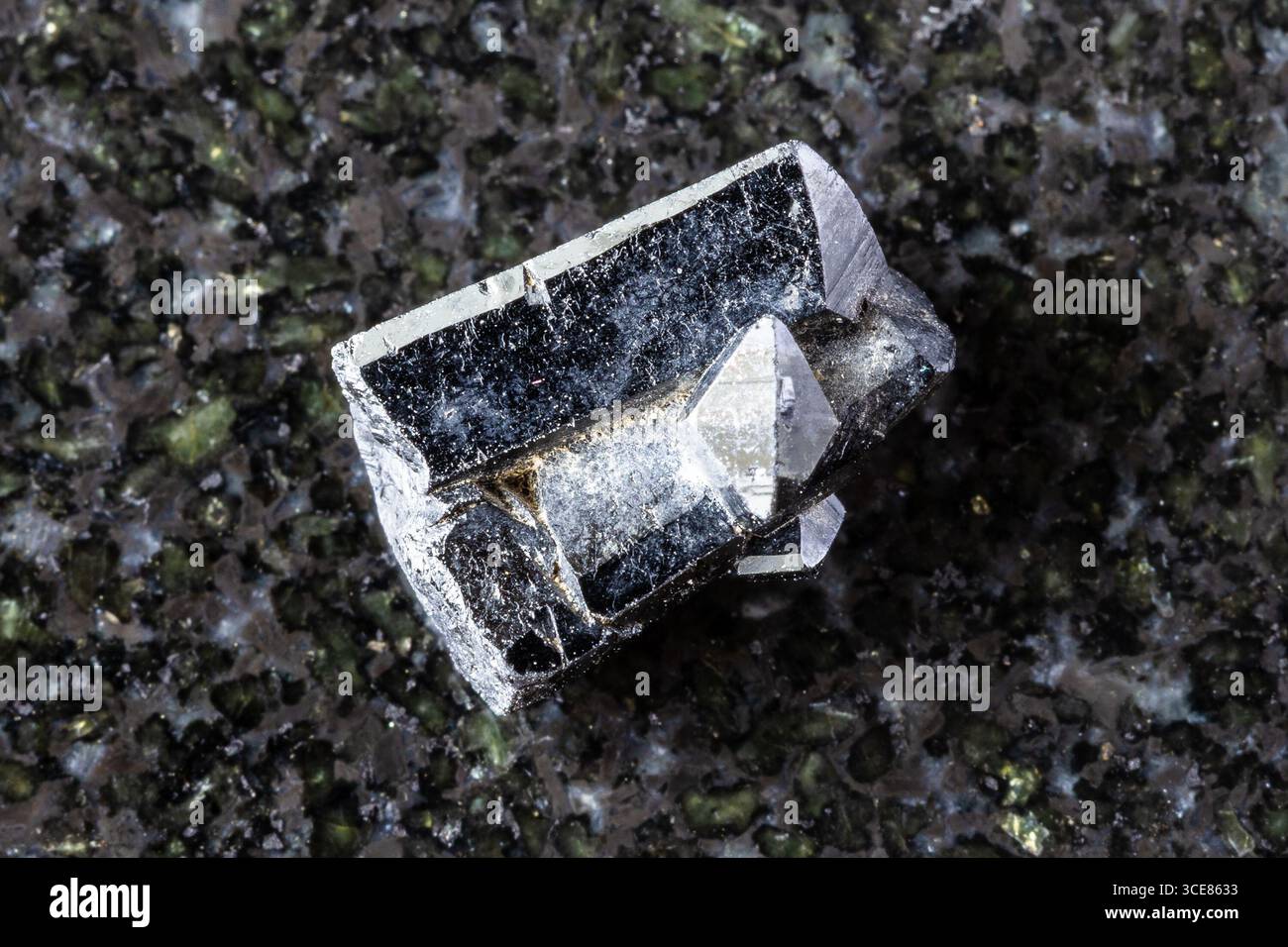 sample of raw ilvaite mineral on black granite background close up from ...