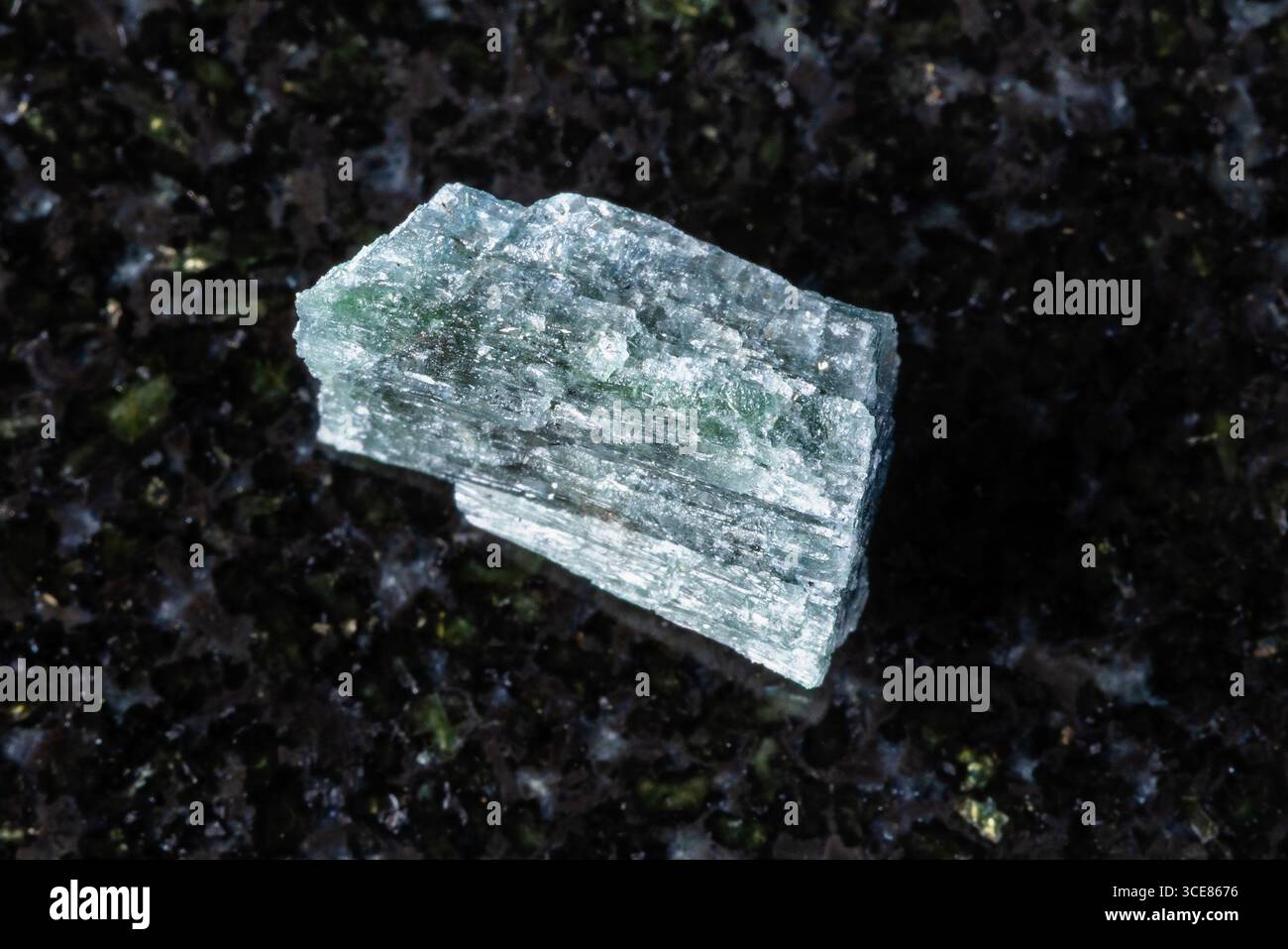 sample of raw indigolite mineral on black granite background close up ...