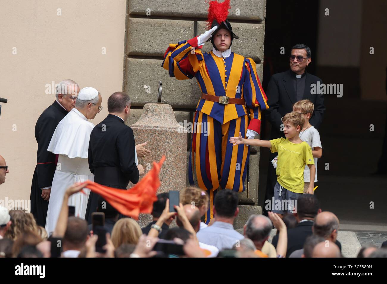 The Pope meets two children dressed in the Vatican colors, white and ...