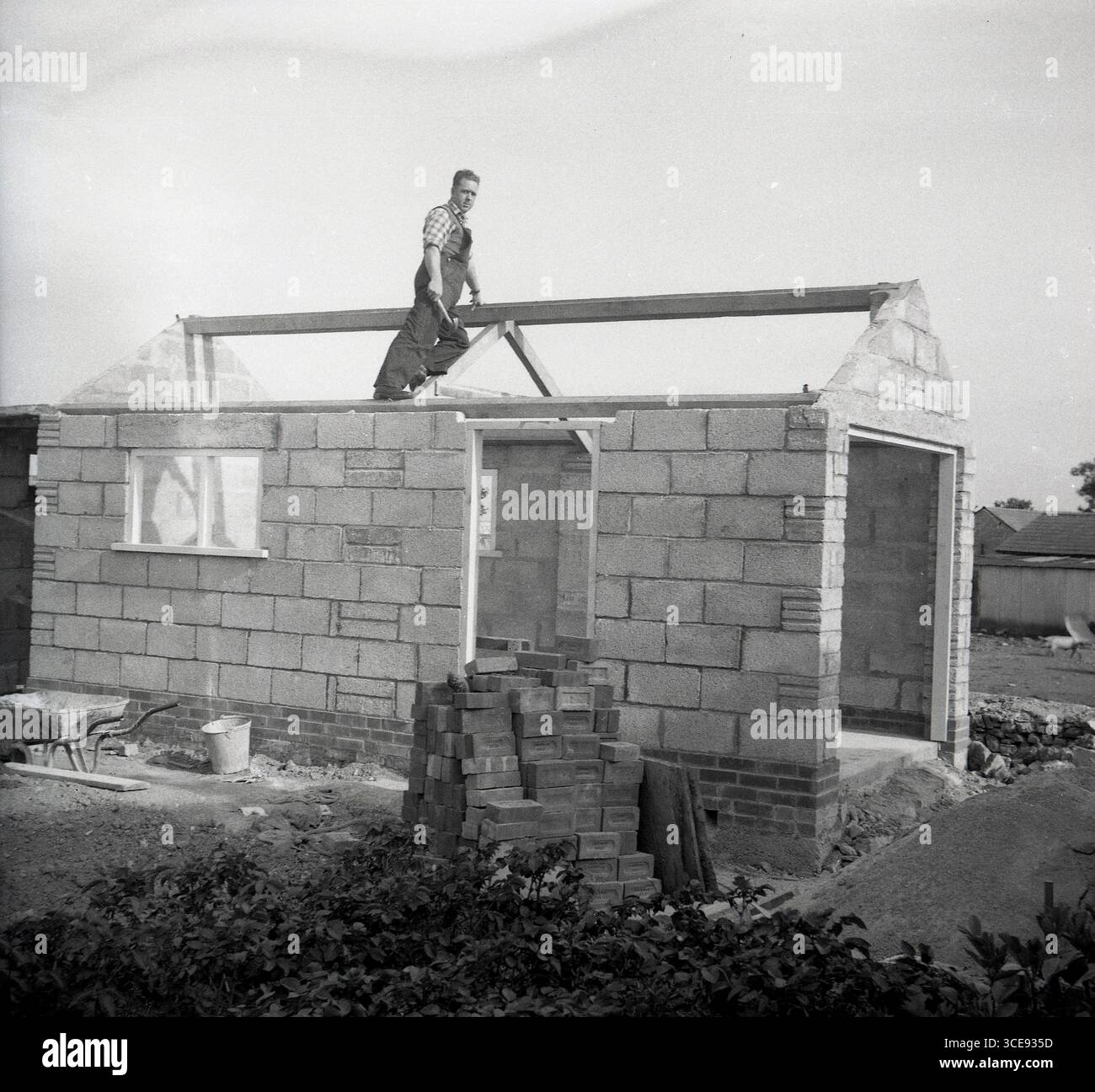 1950s, historical, a workman building a new garage, made from breeze ...