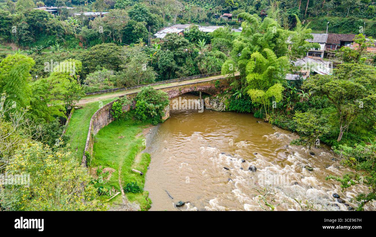 Aerial view of Calicanto Bridge over a river, surrounded by lush ...