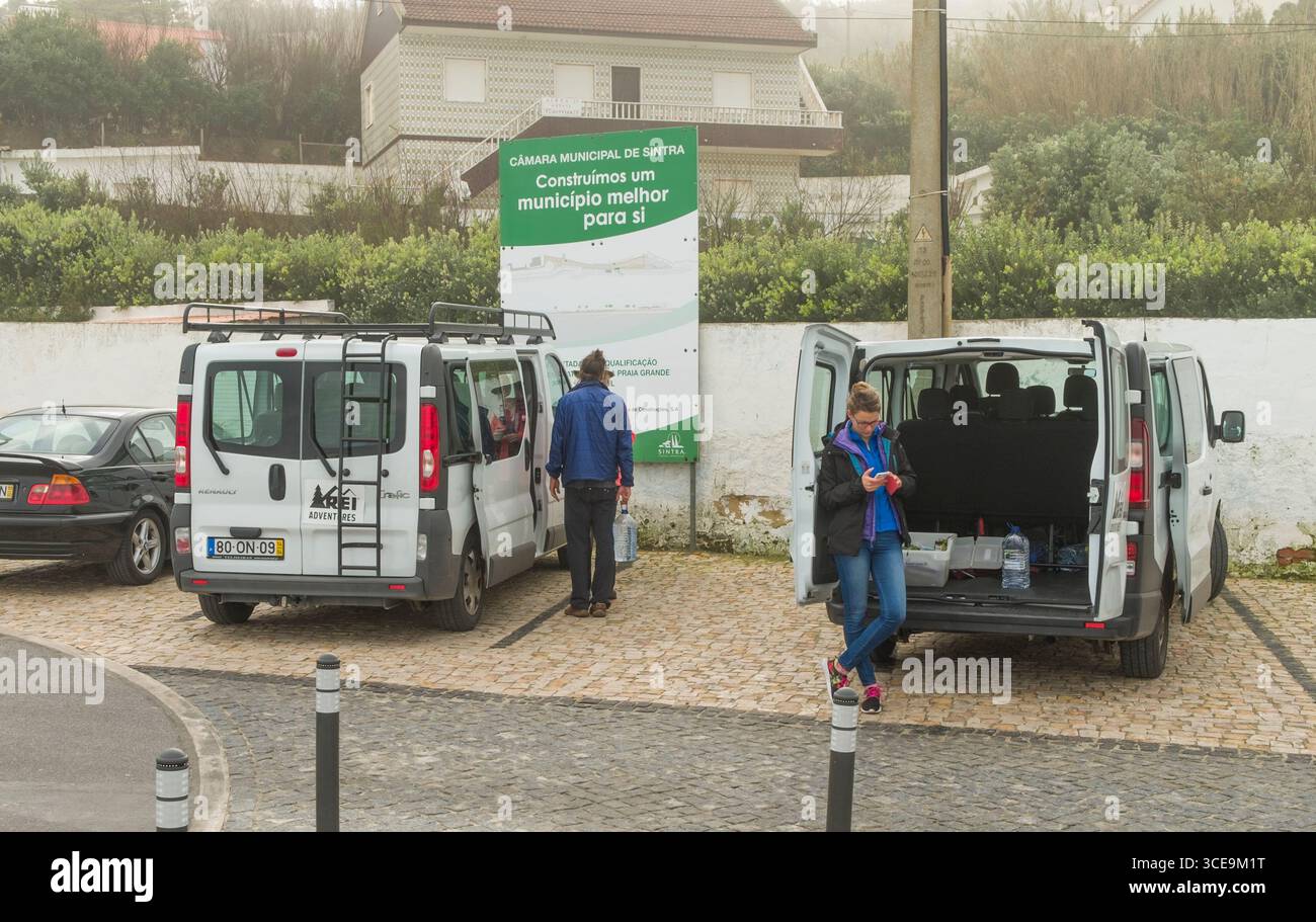 Local Portuguese guides standing next to passenger vans at Praia Grande ...