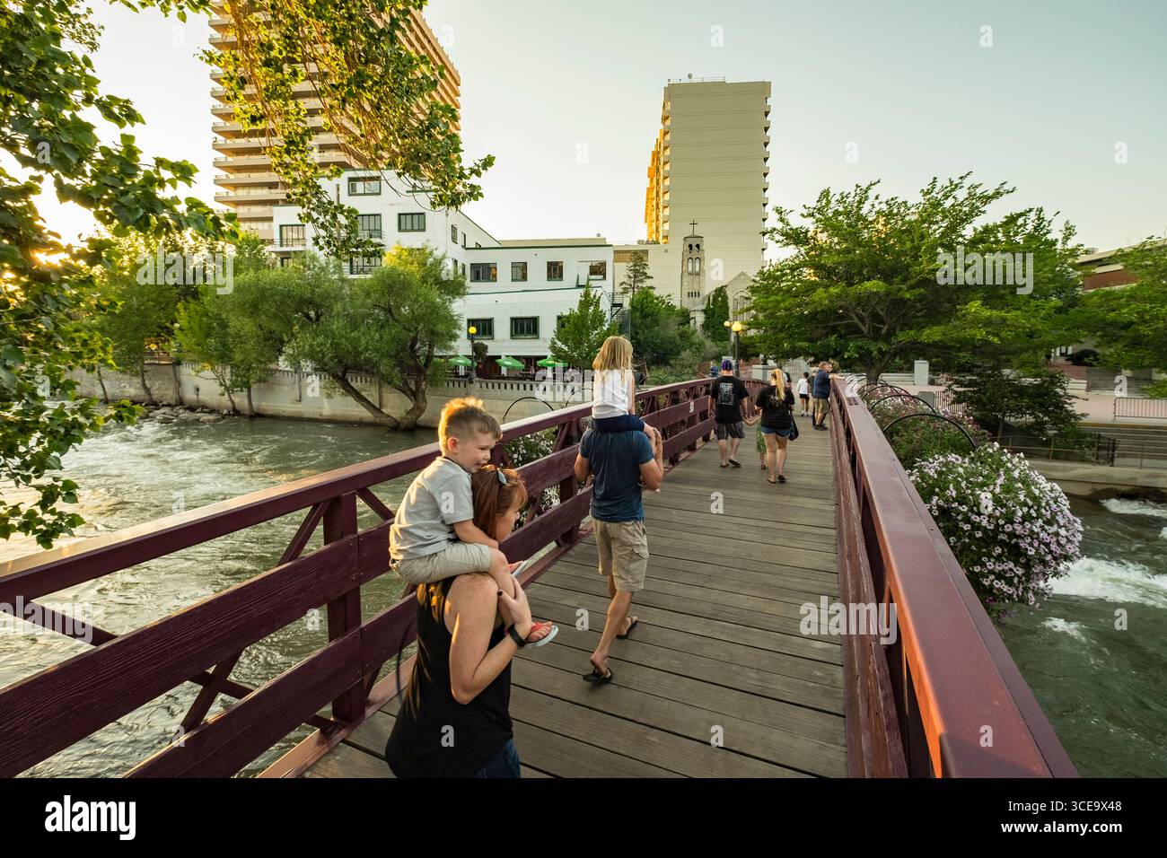 People walking on pedestrian bridge spanning the Truckee River near ...