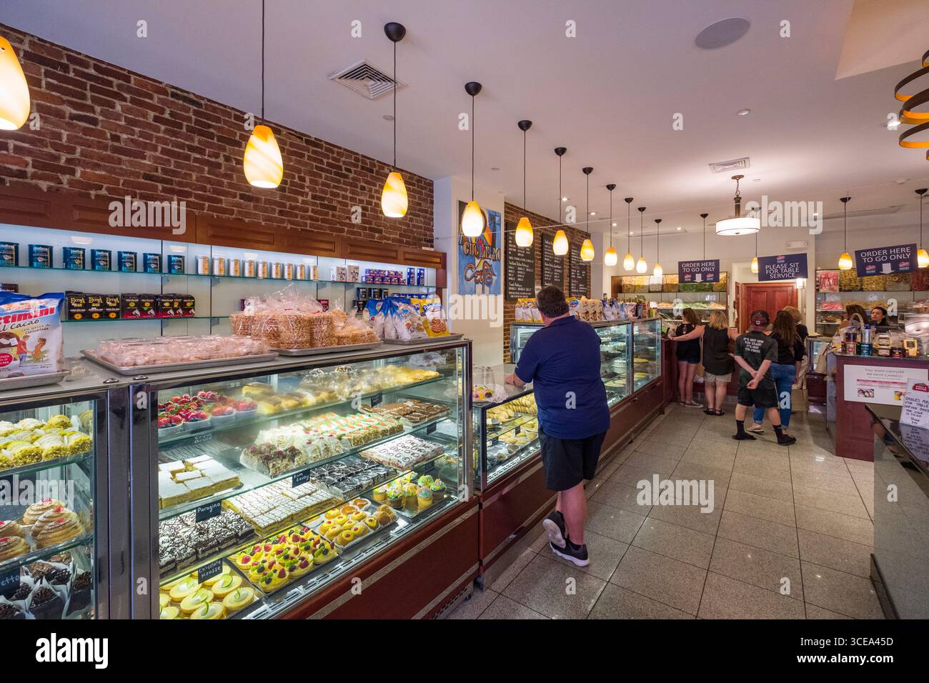 Large selection of pastries and baked goods on display in refrigerated ...