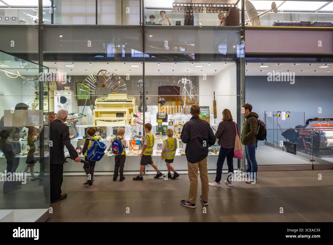 Group of school children looking at display of house hold items from ...